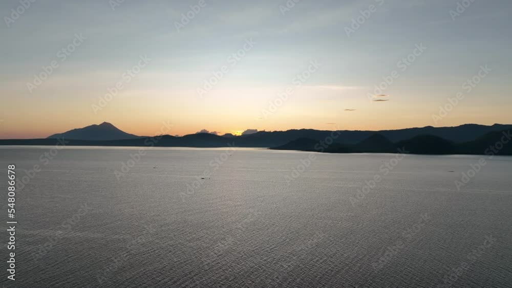 A tranquil sunrise illuminates the beautiful island of Lembata, among ...