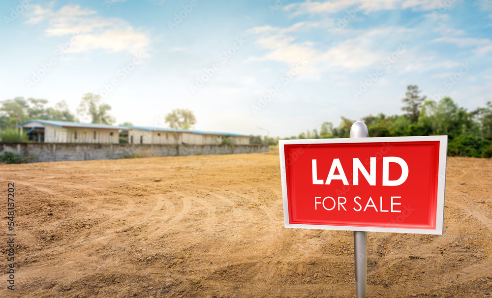 land for sale sign against trimmed lawn background. Empty dry cracked ...