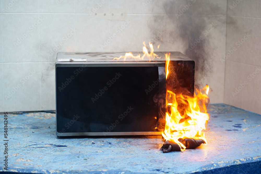 microwave oven on fire. the concept of fire in the kitchen and malfunctions, breakdowns of ...