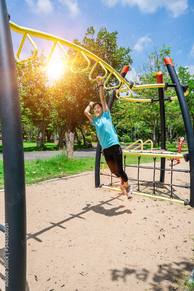 Cute child girl hanging hanging on monkey bars at the playground in ...