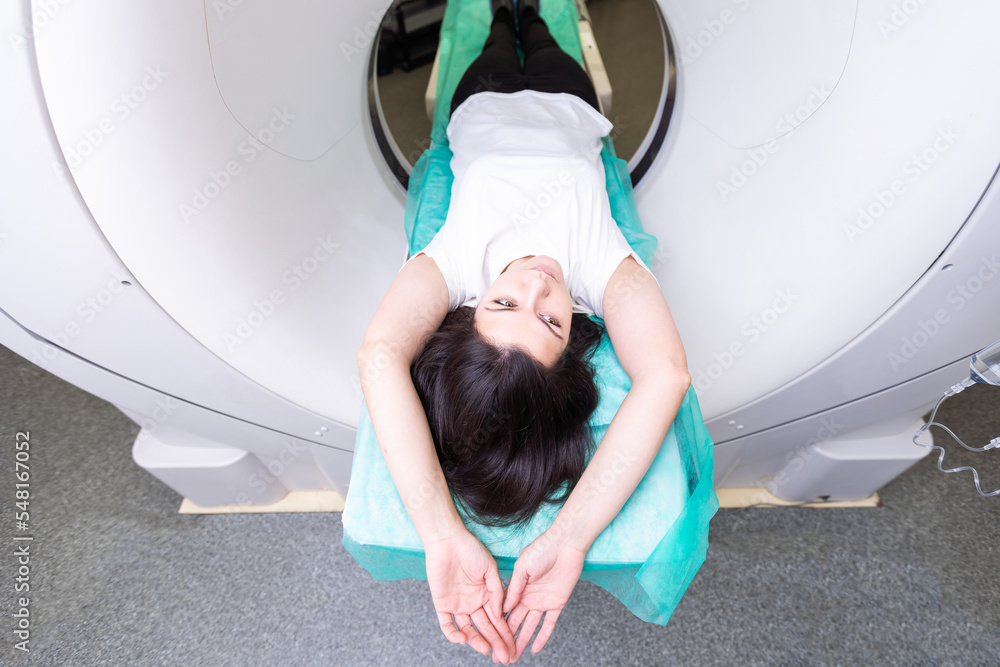 beautiful woman lying on ct scanner bed during tomography test in ...