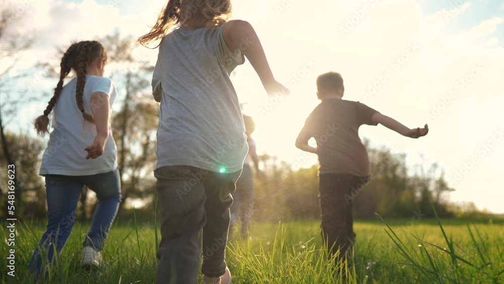 kids run in the park. a large group of a team of children running back ...