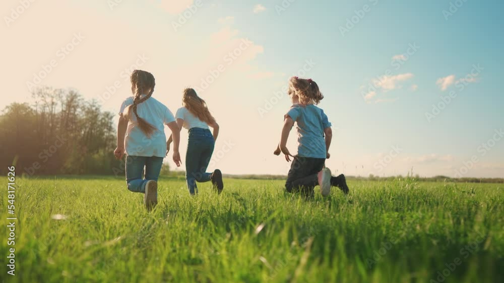 kids run in the park. a large group of a team of children running back ...