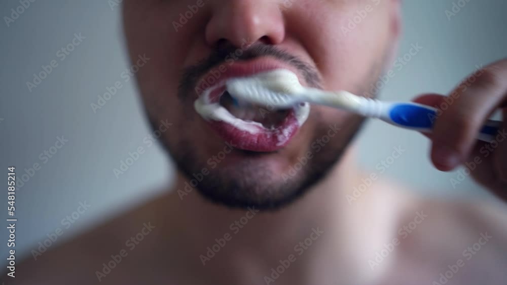 Man brushing teeth with toothbrush and toothpaste. Smiling handsome guy enjoying morning oral ...