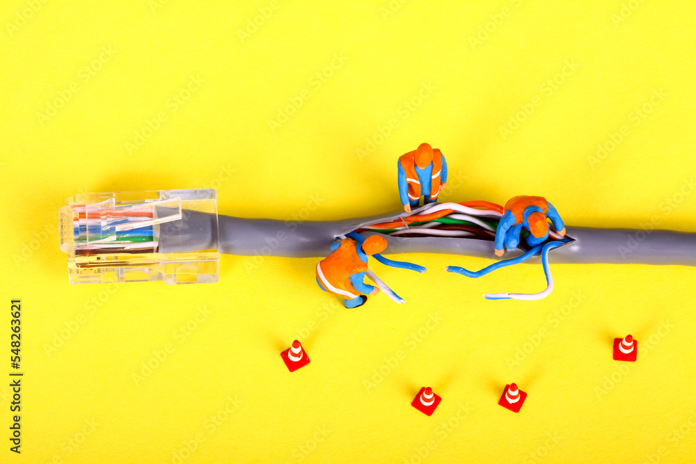 Conceptual image of miniature figure workmen investigating a fault on a ...