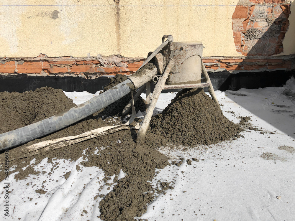 Portland cement mortar machine pouring mortar in a walkable roof. Photo ...