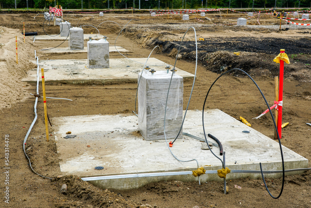 Row of concrete footings for steel columns at the construction site of ...
