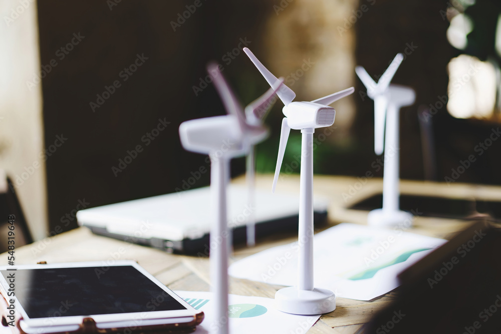 Close up of wind turbines on a table with data sheets, tablet and ...