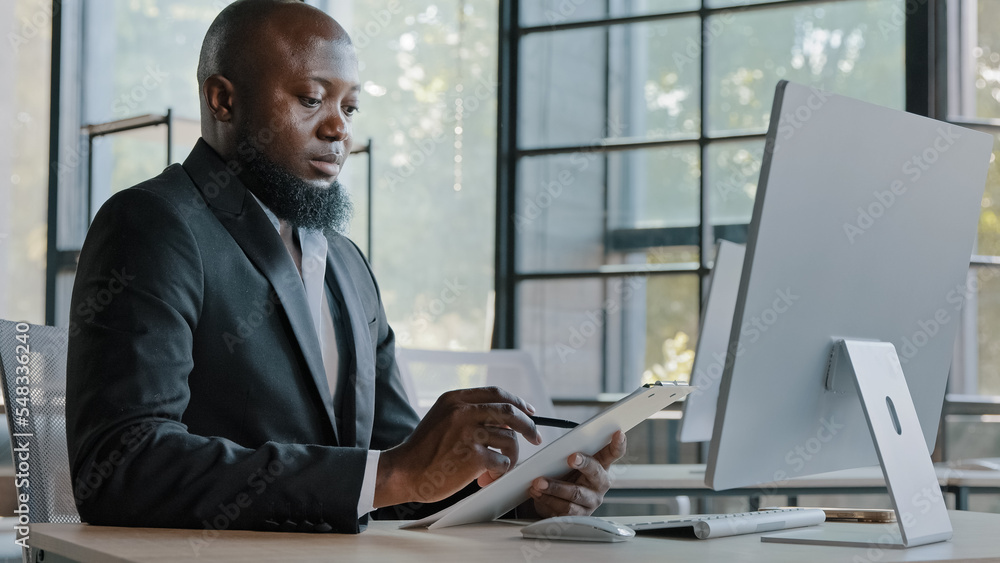 African writer writing notes on paper tablet sit at office desk adult ...