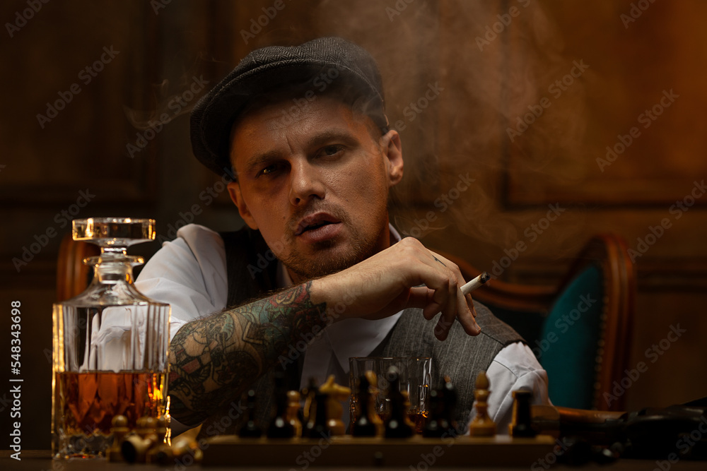 Young gangster smoking and drinking alcohol while playing chess Stock ...