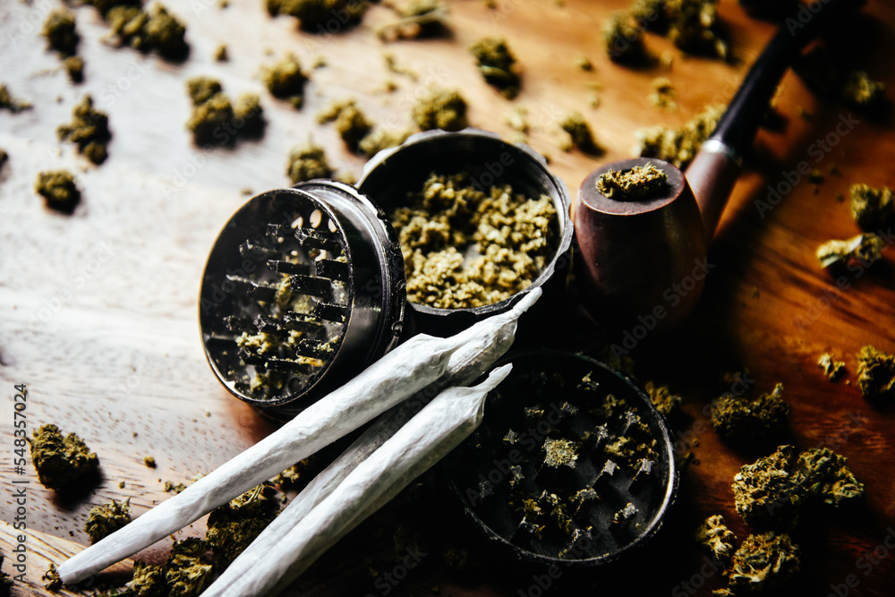 Grinder and joints with marijuana pipe. Drugs and marijuana, marijuana buds. Sativa and indica ...
