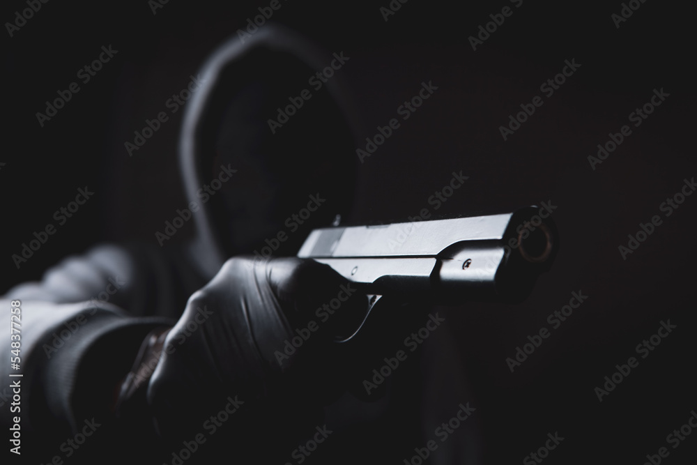 masked man holding a gun Stock Photo | Adobe Stock