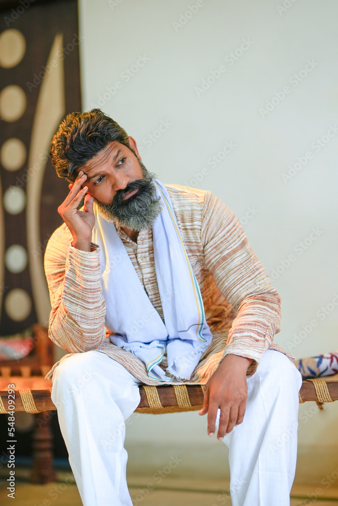 Indian farmer seating in stress at his home. Stock Photo | Adobe Stock