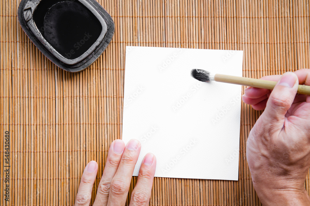 Abstract man hand white paper with bamboo calligraphy brush and ...