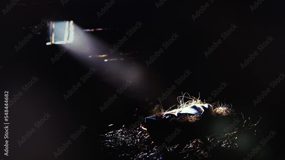 Bright light from the window illuminates the baby Jesus in the manger ...