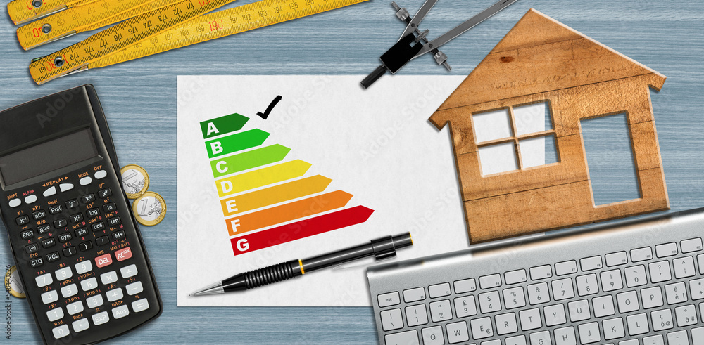 House energy efficiency rating. Small wooden model house on desk with ...
