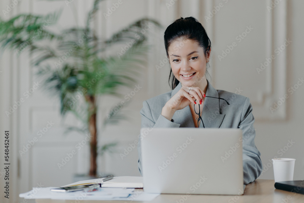 Cheerful young professional woman searches update notification for ...