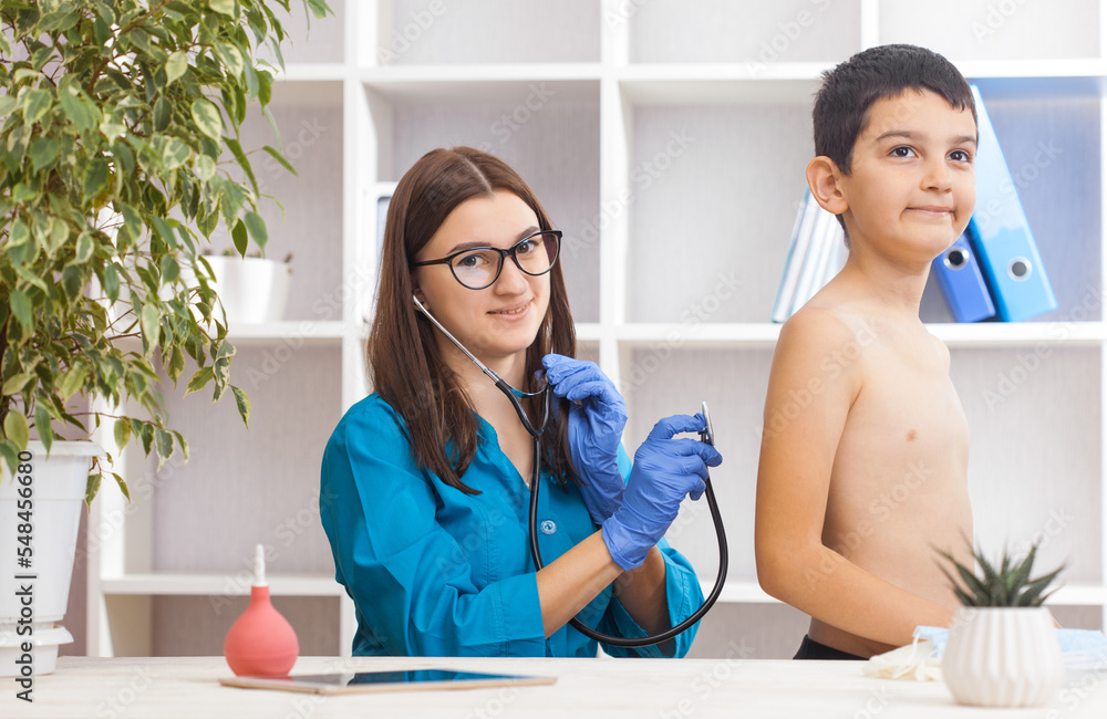 female doctor or pediatrician with stethoscope listening to heartbeat ...