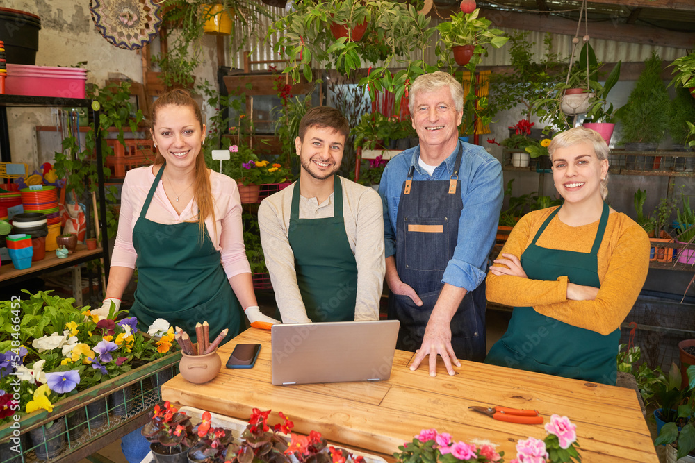 Smiling florists team in flower shop at laptop Stock Photo | Adobe Stock