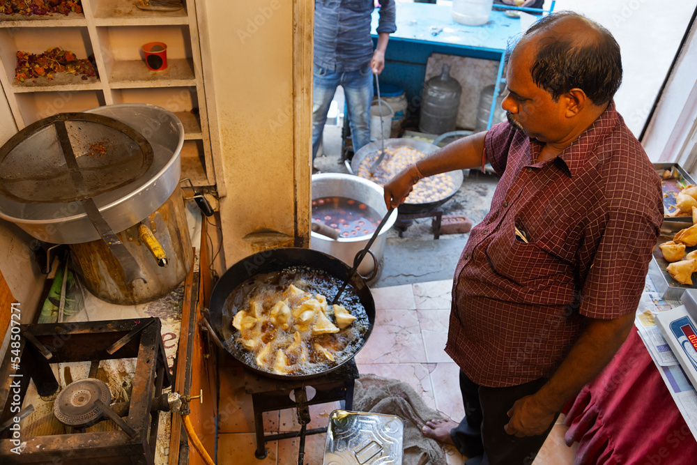 Owner of a sweet shop known as a Halwai making Samosas, a popular ...