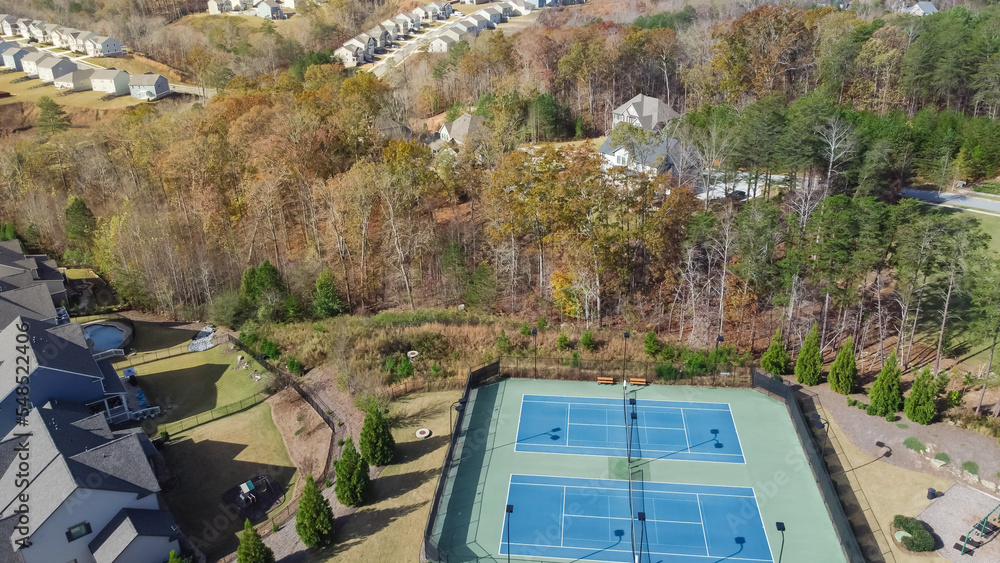 Aerial view subdivision sprawl with row of houses and 2 tennis court ...