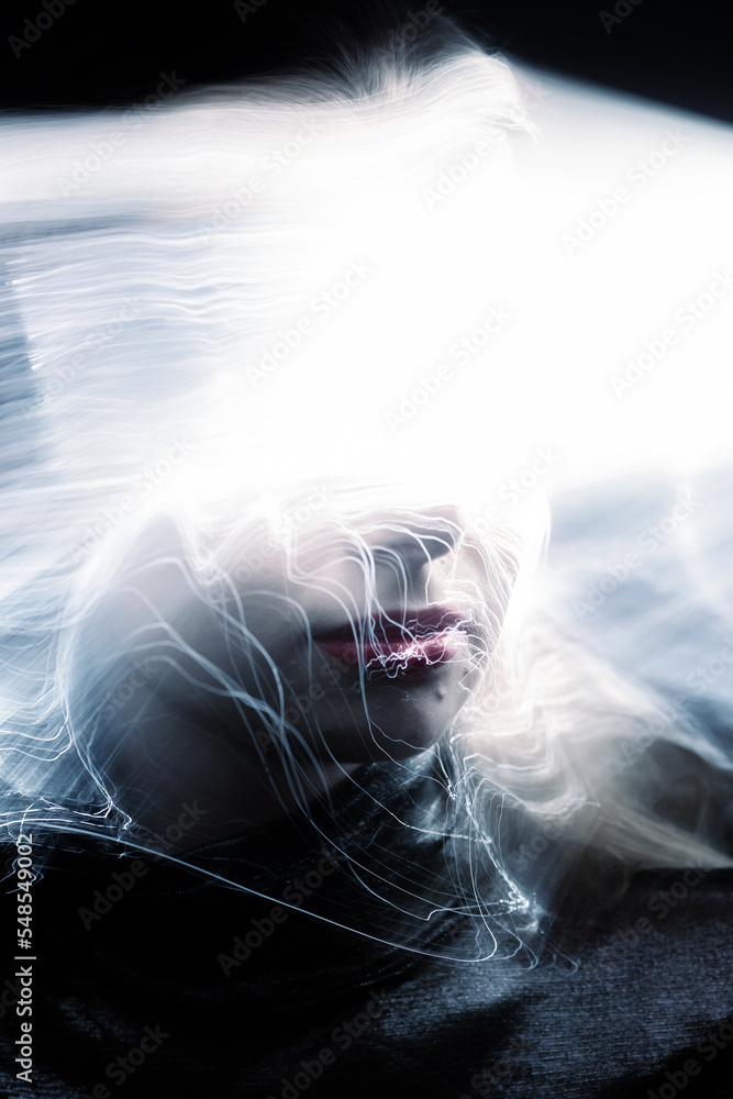 Abstract woman face silhouette in bright light trails of light painting ...