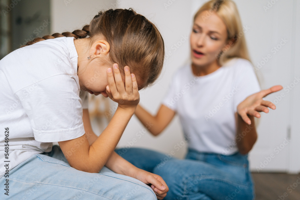 Close up side view of upset cute little girl crying covering face with ...