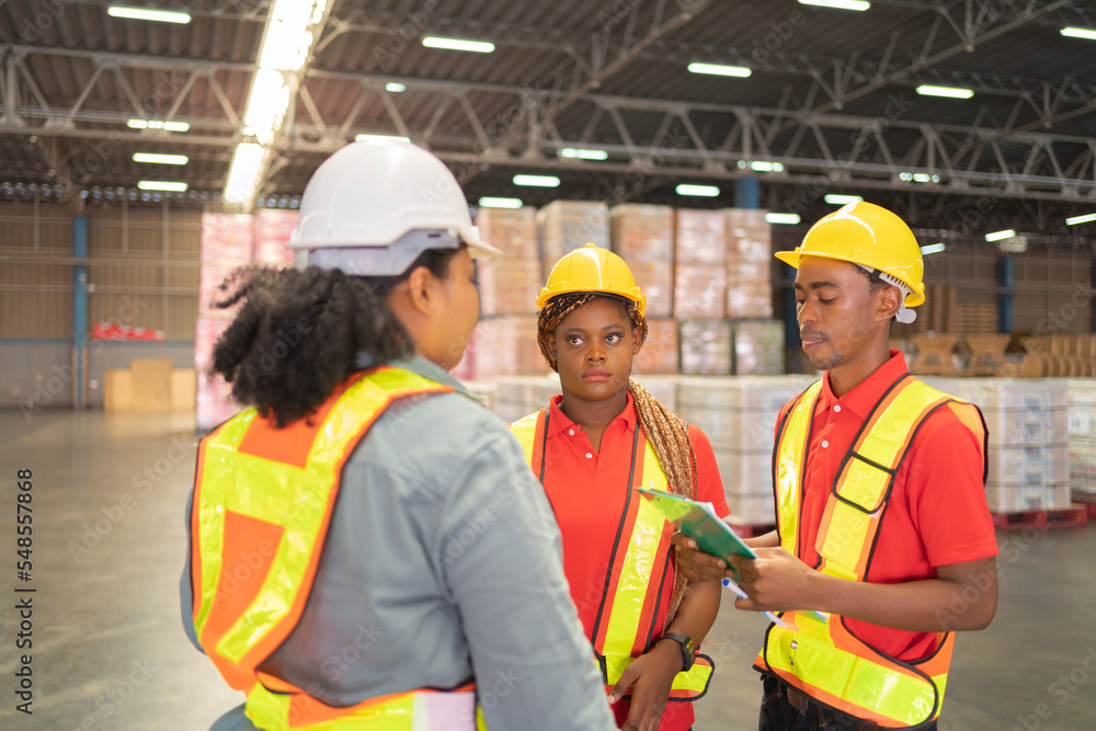 Teamwork of black workers and fat woman working in large warehouse ...