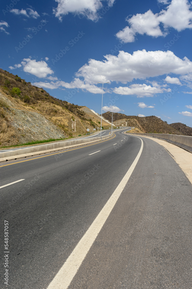 Carretera con curvas en ascenso entre las montañas. Día soleado con ...