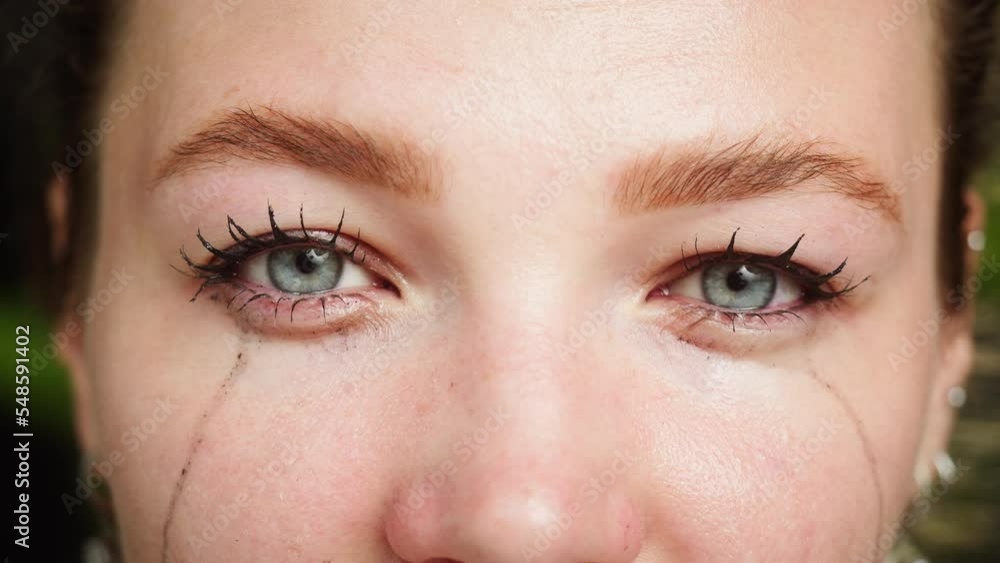 Close-up of crying blue eyes, watery eye of young woman, shooting of ...