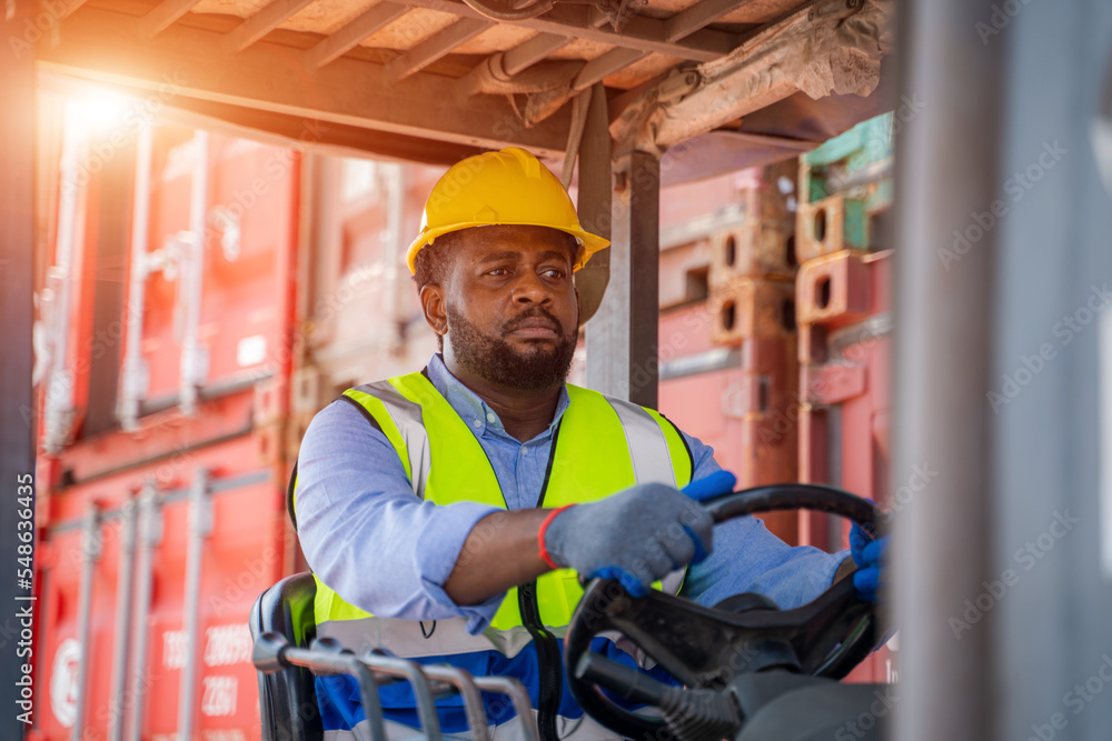 Technician operates a forklift tractor to move containers around the ...