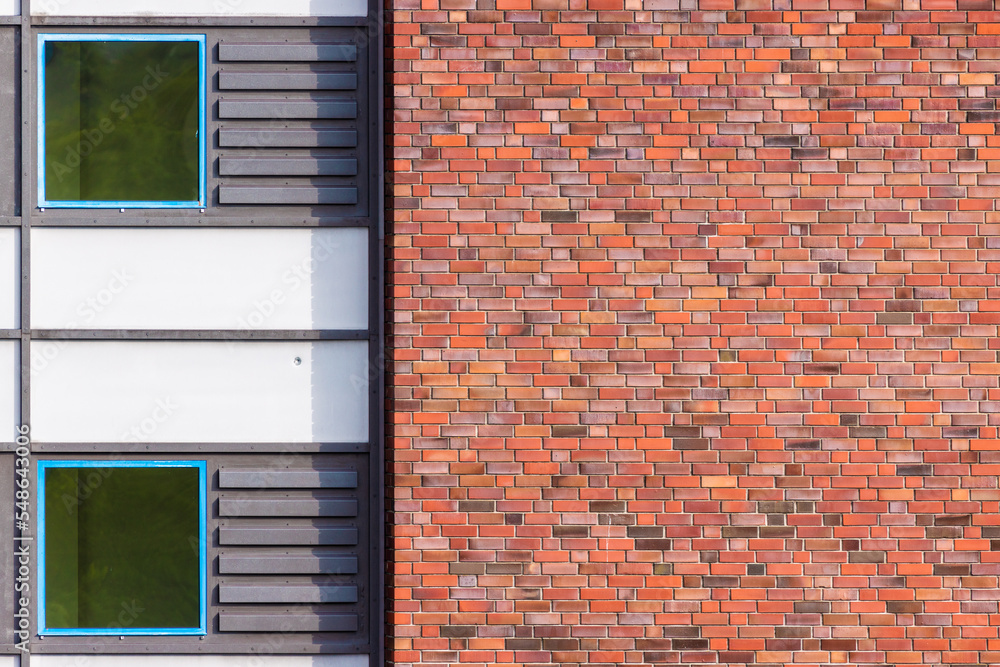 Facade detail of a building with brick wall, blue window frames and ...