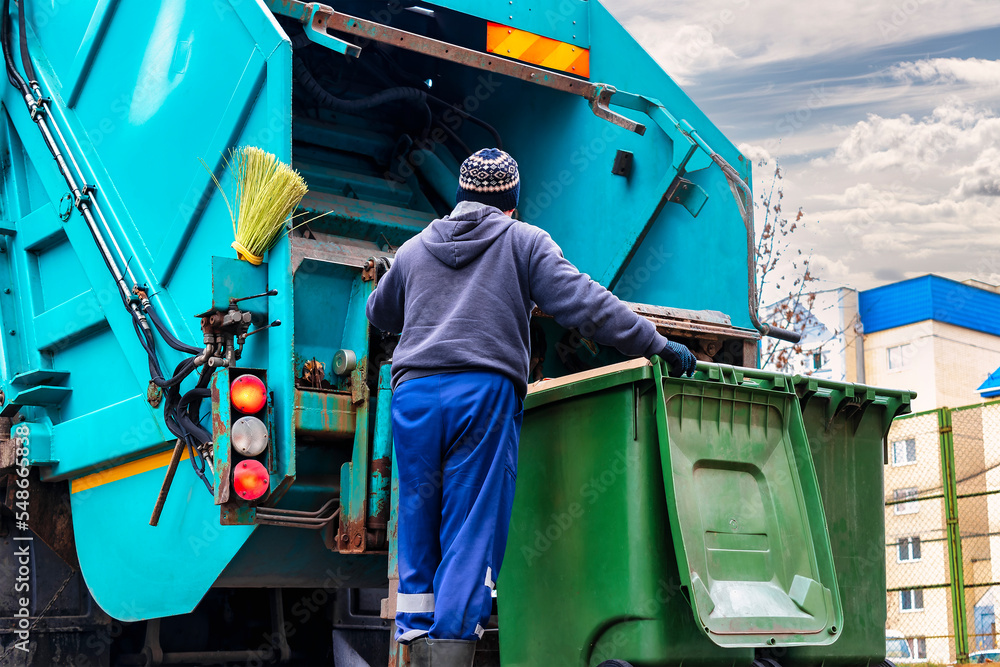 A garbage truck picks up garbage in a residential area. Loading mussar ...