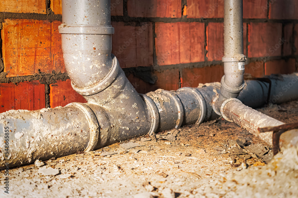 Sewer pipes in home basement. System of gray sanitary pipes when ...