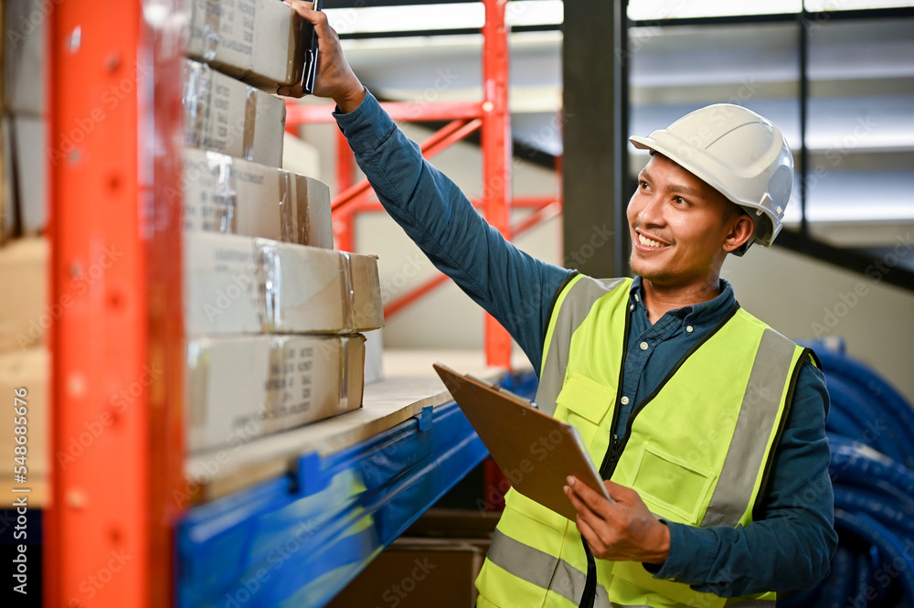 Asian male warehouse manager checking an inventory, working in ...