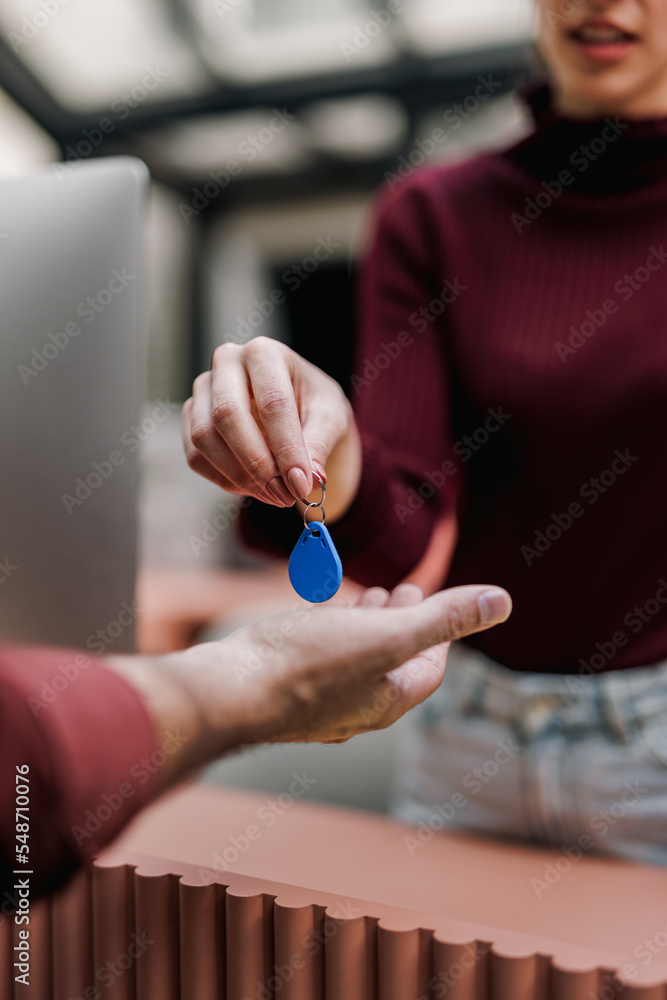 Businesswoman giving a token for the door opening to the new male ...