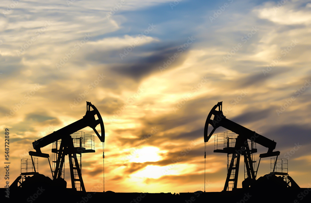 Oil drilling derricks at desert oilfield. Crude oil production from the ...