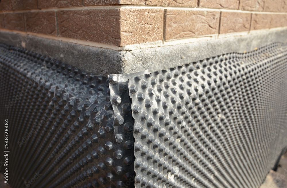 Basement waterproofing outdoors. Installation of a dimpled ...