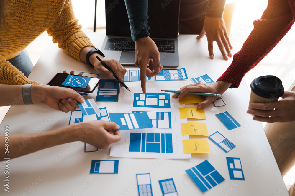 Working at desk, start up, UX team works from a single location under a ...