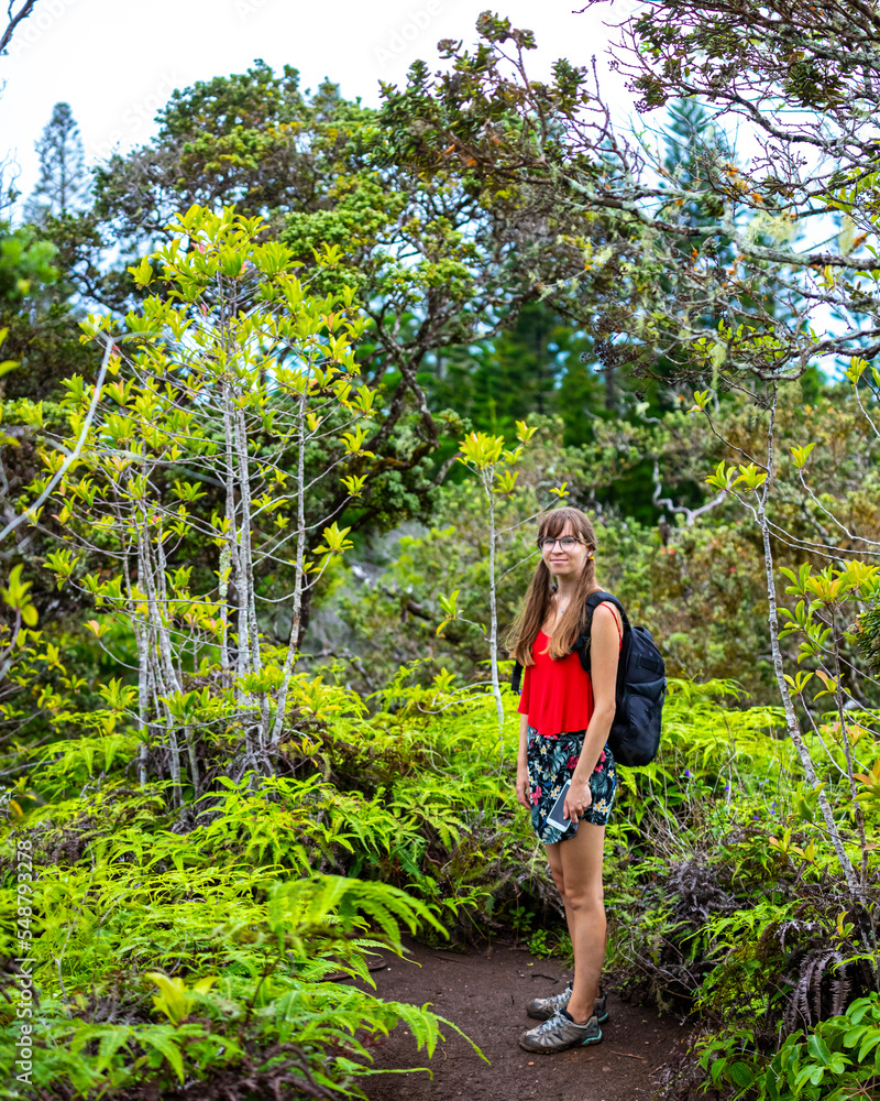 a beautiful hiker girl walks along a bushy path while climbing the ...