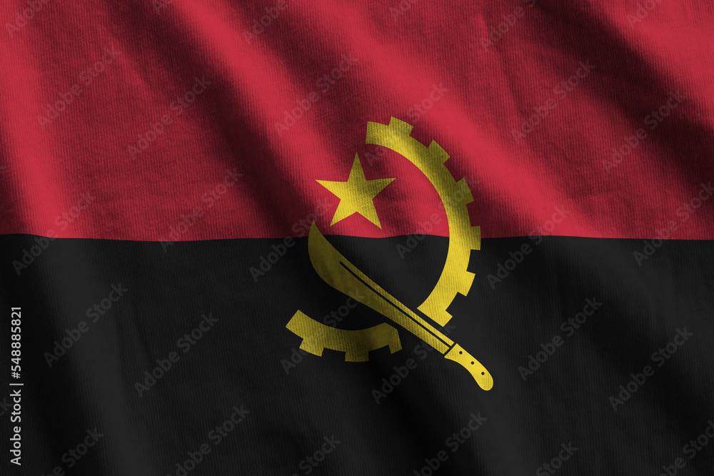 Angola flag with big folds waving close up under the studio light ...