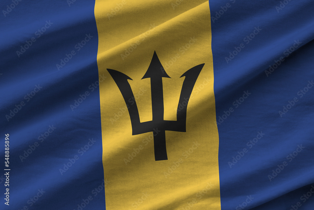 Barbados flag with big folds waving close up under the studio light ...