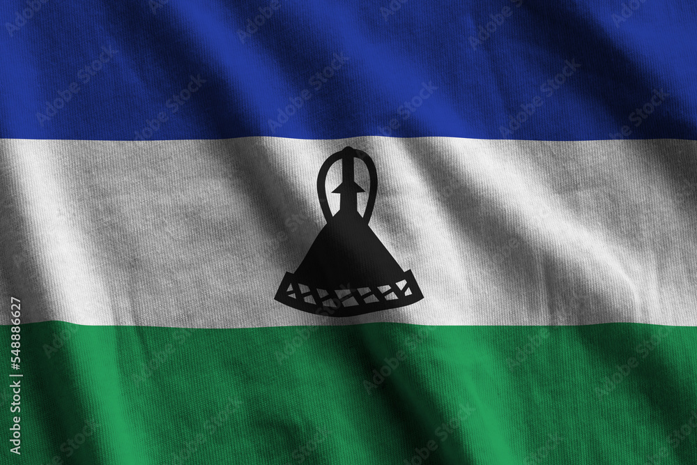 Lesotho flag with big folds waving close up under the studio light ...
