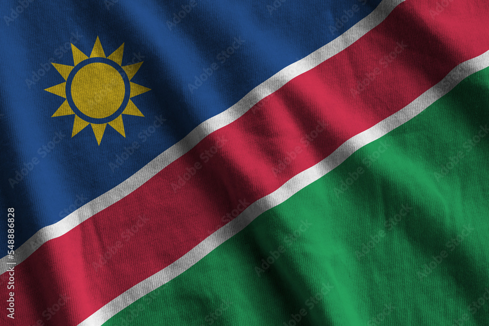 Namibia flag with big folds waving close up under the studio light ...