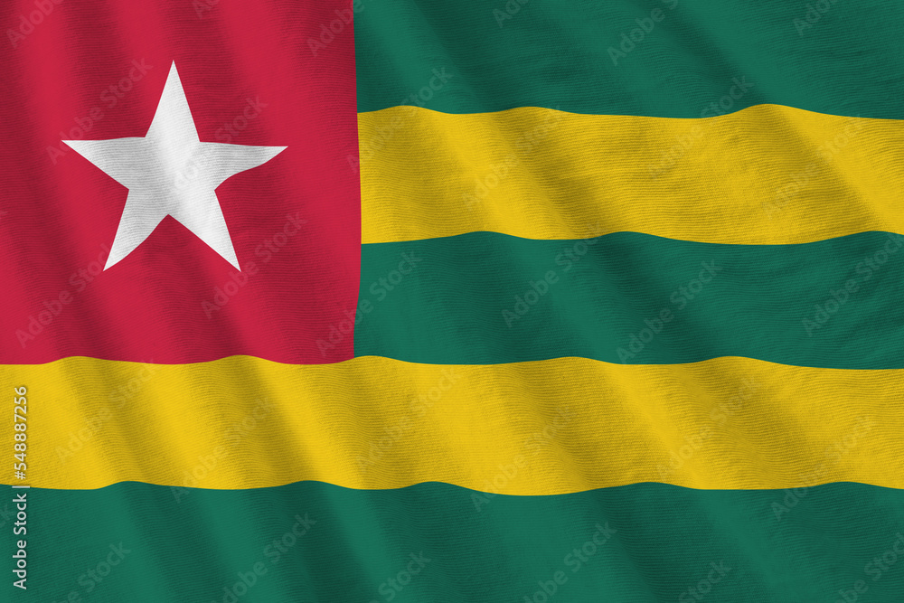 Togo flag with big folds waving close up under the studio light indoors ...