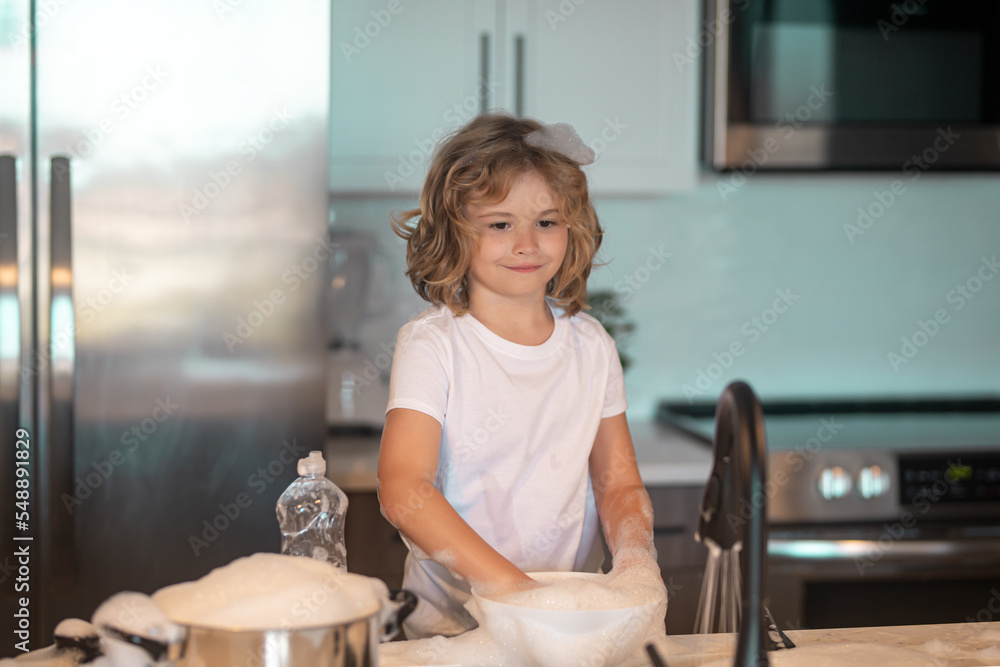 Child boy washing the dishes in the kitchen sink. Clean washed dishes ...