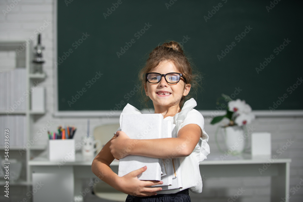 Back to school. Cute child nerd with books at school. Kid is learning ...