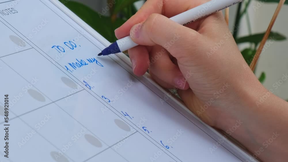 Female hand writing text TO DO LIST with marker on whiteboard. Making ...