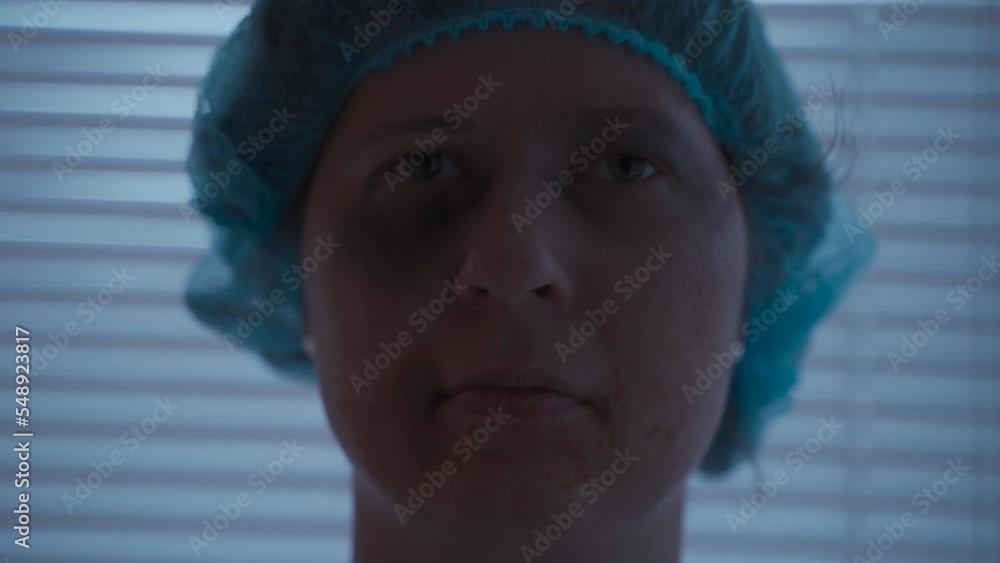 A scared, traumatized woman with injuries to her teeth and face looks ...