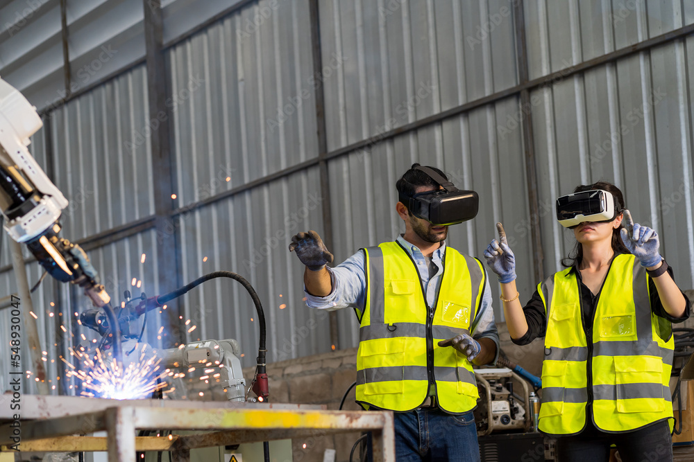 Male engineer and female working control robot arm system welding with ...